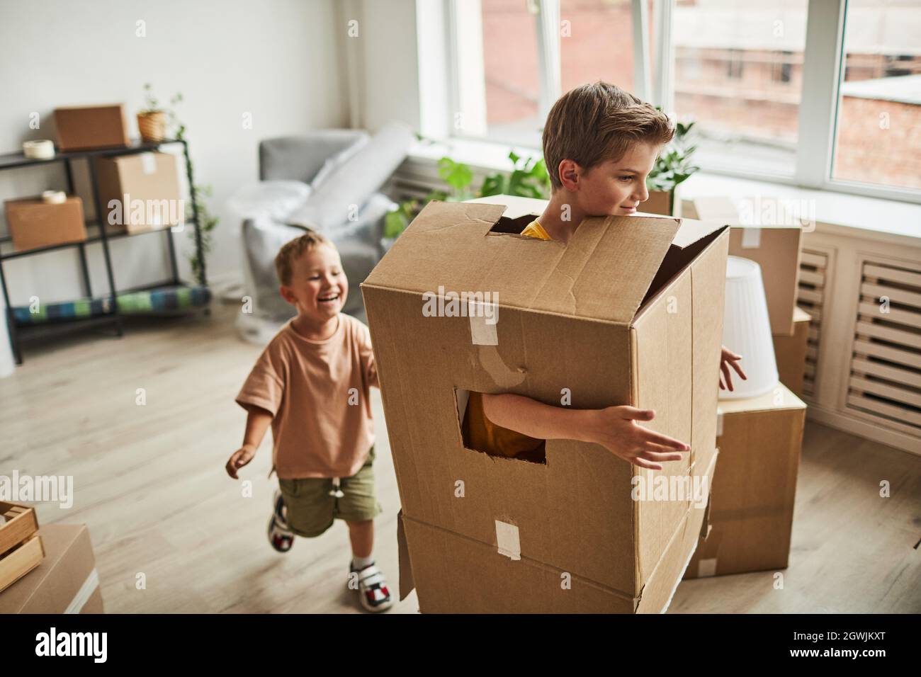 Portrait of two brothers wearing cardboard boxes and playing while ...
