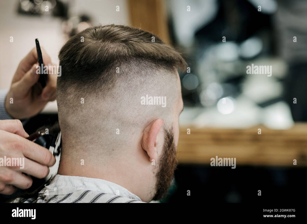 Hairstylist serving client at barber shop. Back view Stock Photo - Alamy