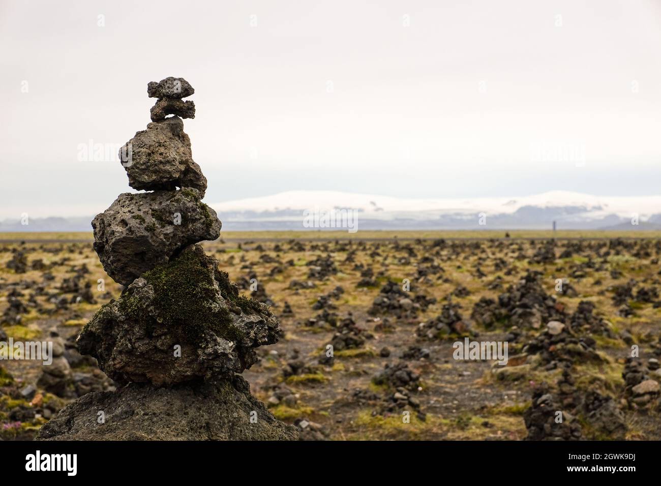 A close up shot of a small built of some stones on a field's dry ground ...