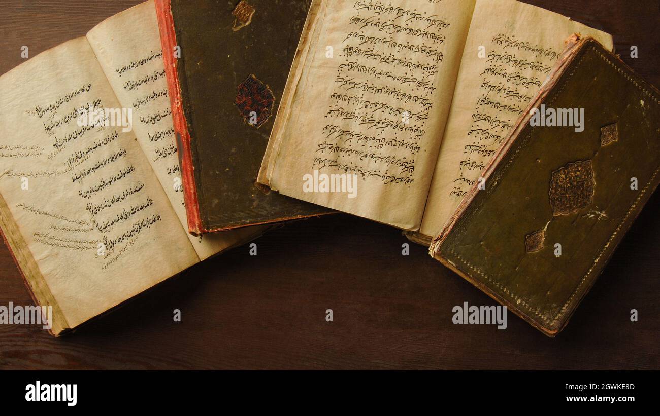 Stack of open ancient books in Arabic. Old Arabic manuscripts and texts ...