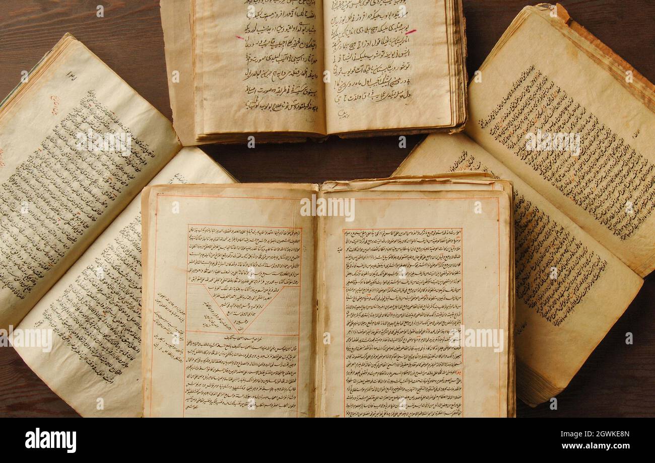 Stack of open ancient books in Arabic. Old Arabic manuscripts and texts ...