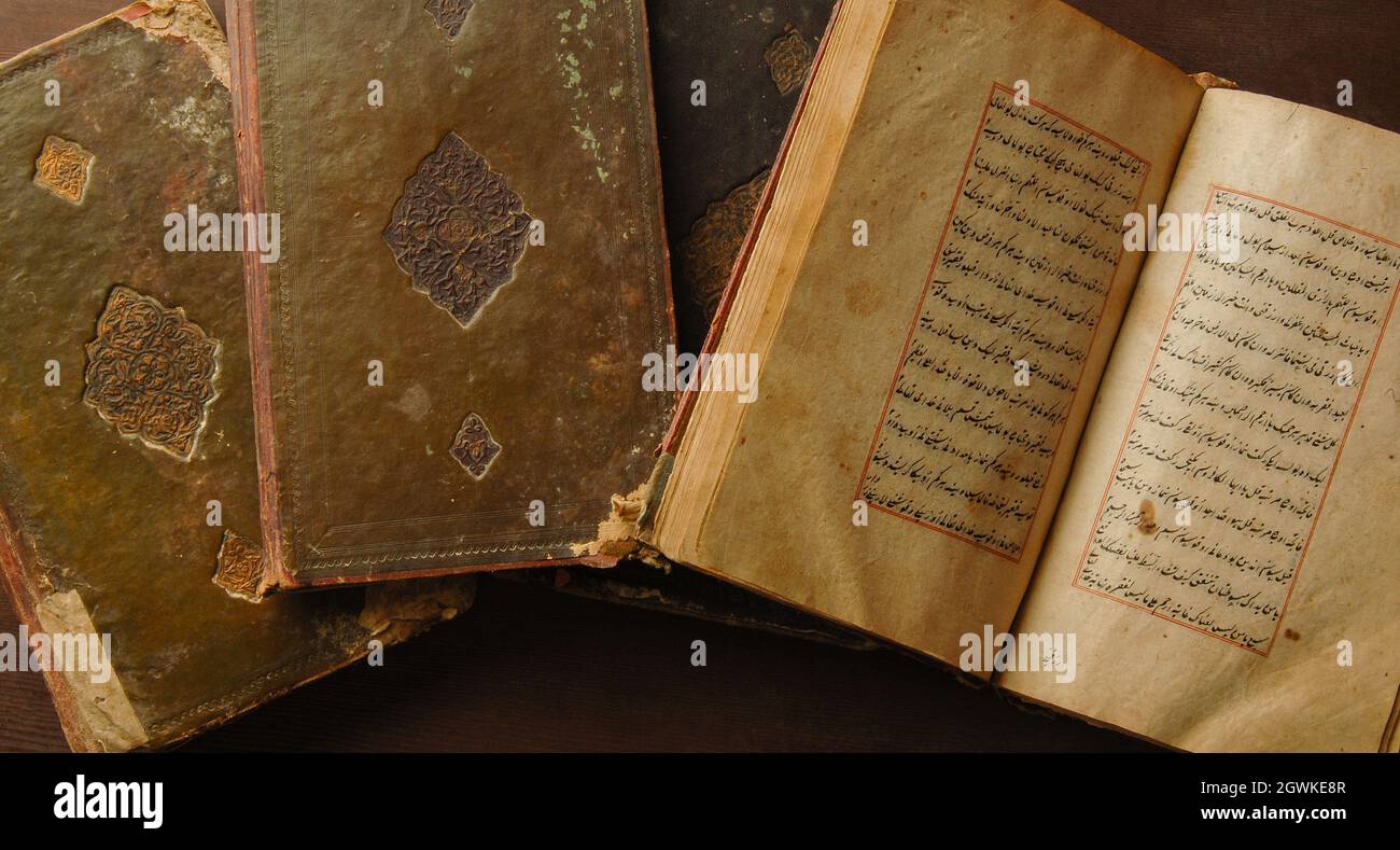Stack of open ancient books in Arabic. Old Arabic manuscripts and texts ...