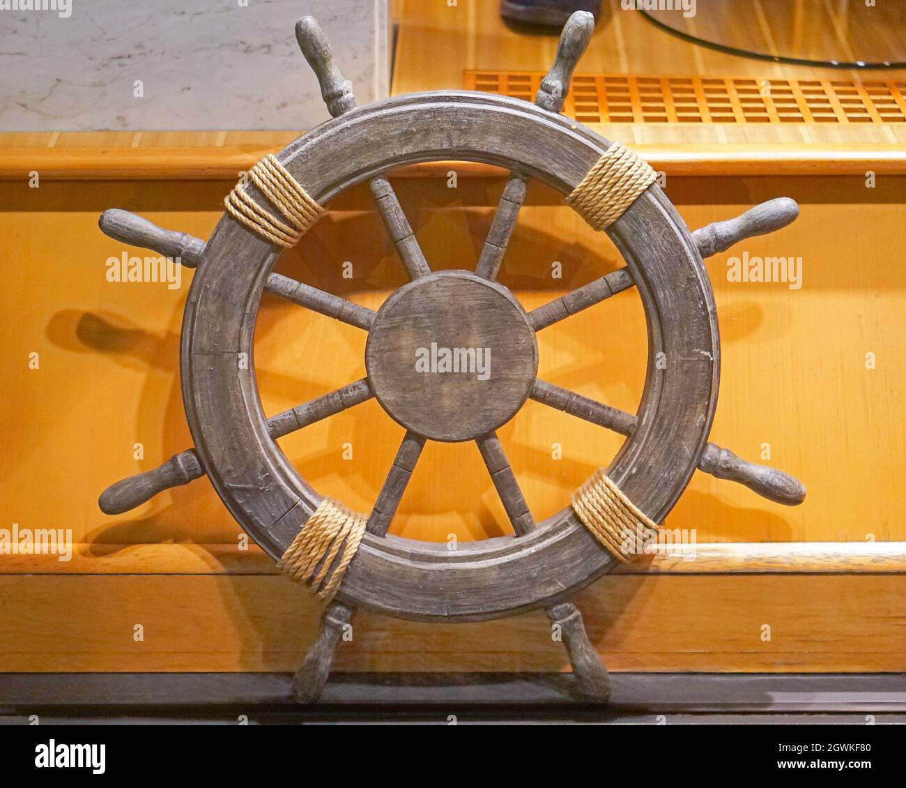 Wooden retro ship wheel with rope decor Stock Photo - Alamy
