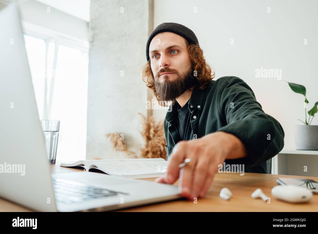 Bearded student study online at campus using laptop. Young man doing ...