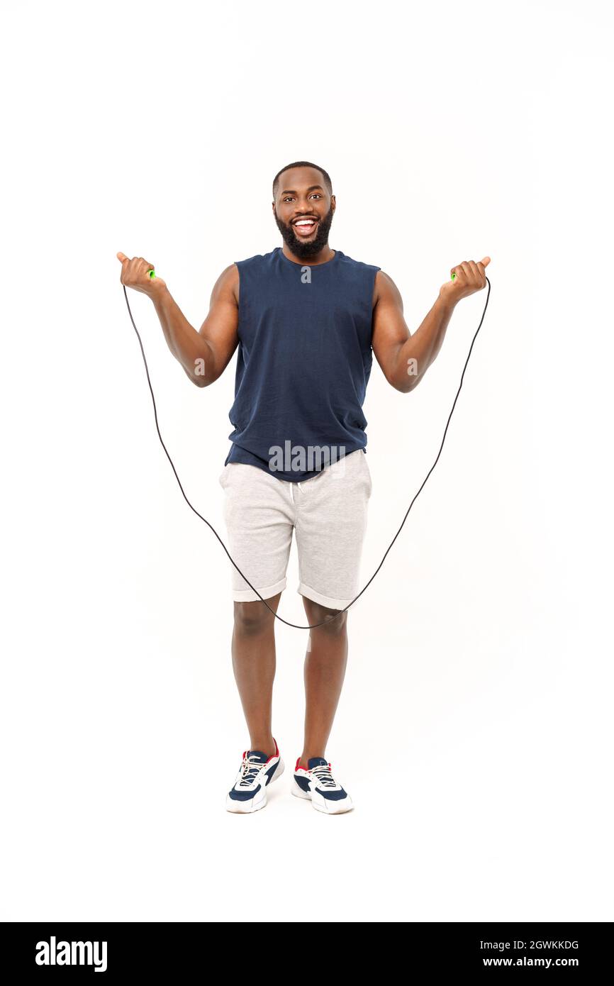 African fitness model with skipping rope against grey background ...