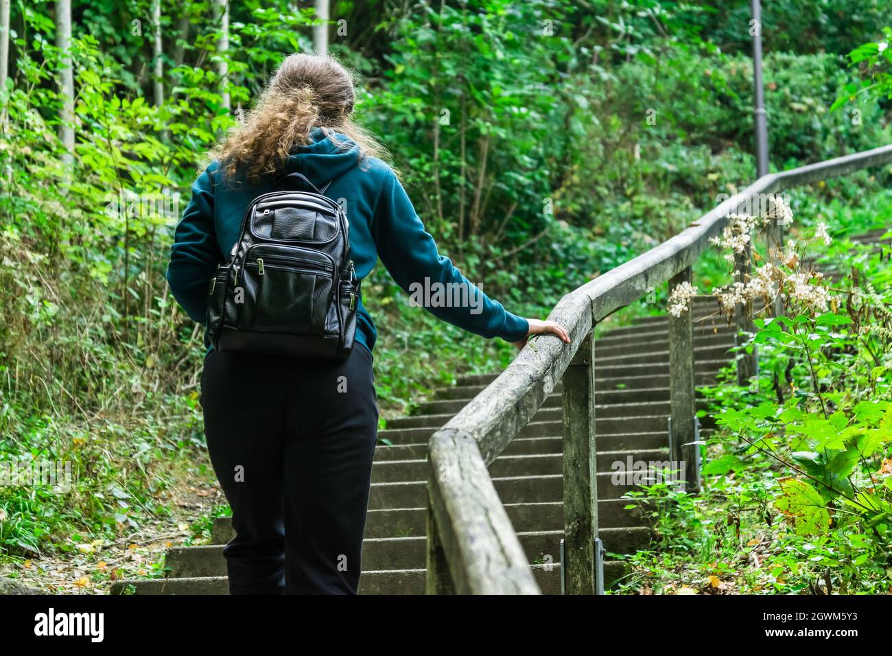 A close up shot of the back of a young girl going up stairs and ...