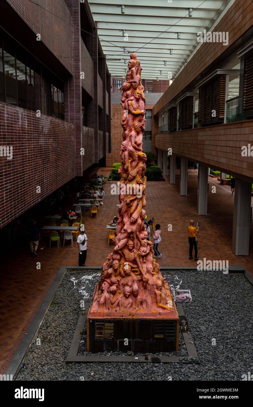 Students and visitors look at the Pillar of Shame. Standing at eight ...