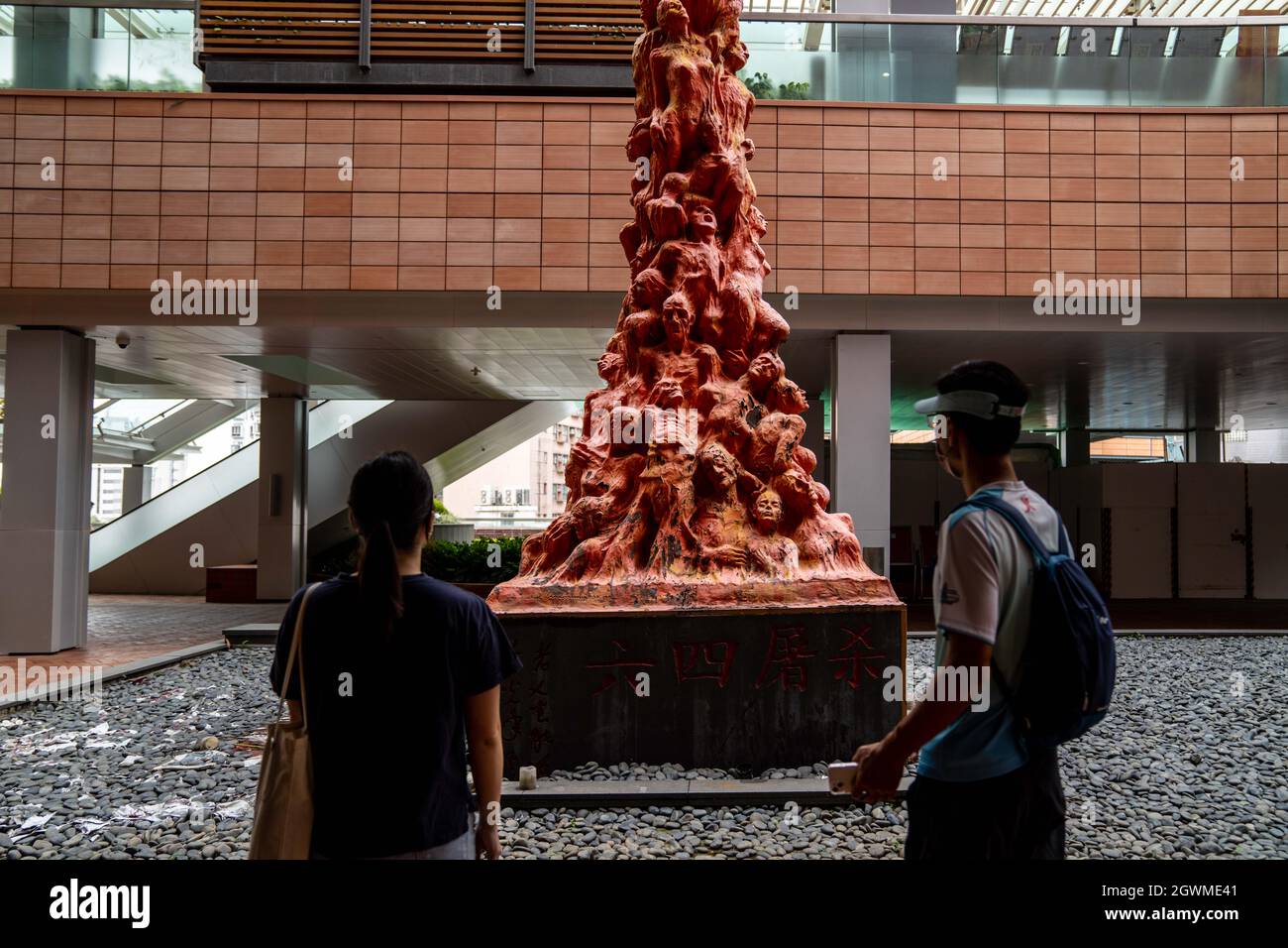 People stand in front of the Pillar of Shame. Standing at eight-meters ...