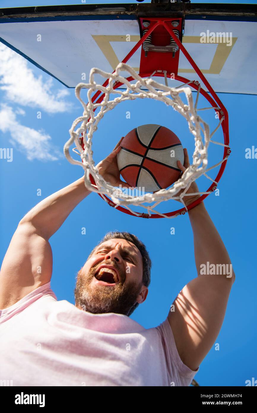 successful man player throw basketball ball through basket, success ...