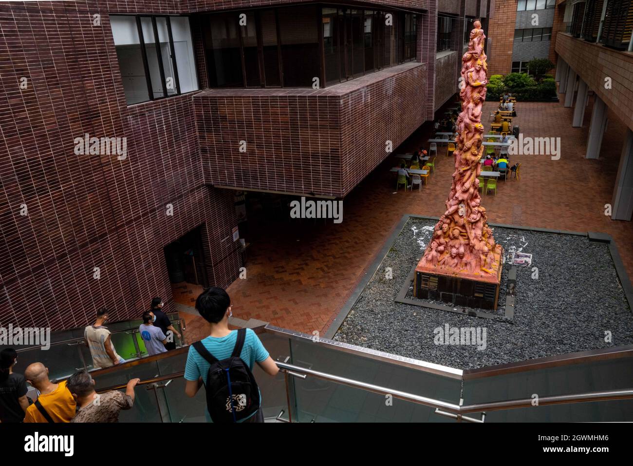 Students and visitors walk towards the Pillar of Shame. Standing at ...