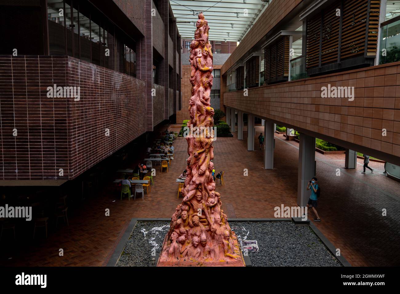 People sit near the Pillar of Shame.Standing at eight-meters tall, the ...