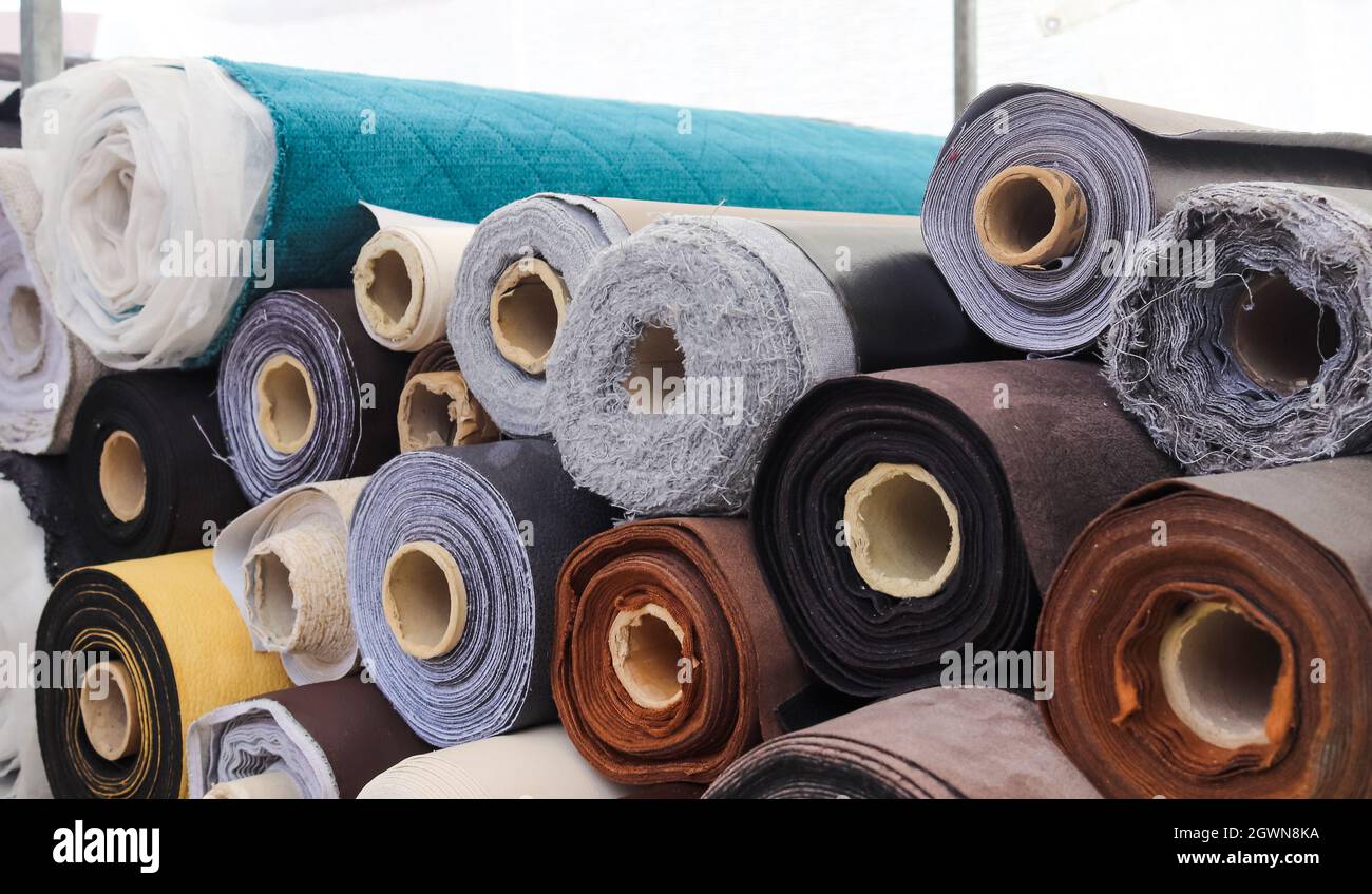 Close up view on rolled samples of cloth and fabrics in different ...