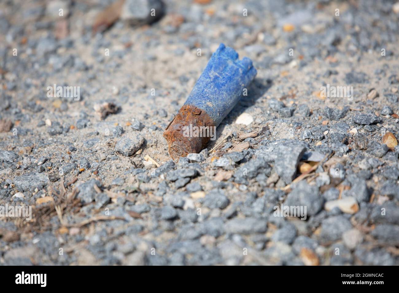 Rusty, discharged blue ammunition shell on the gravel ground Stock ...