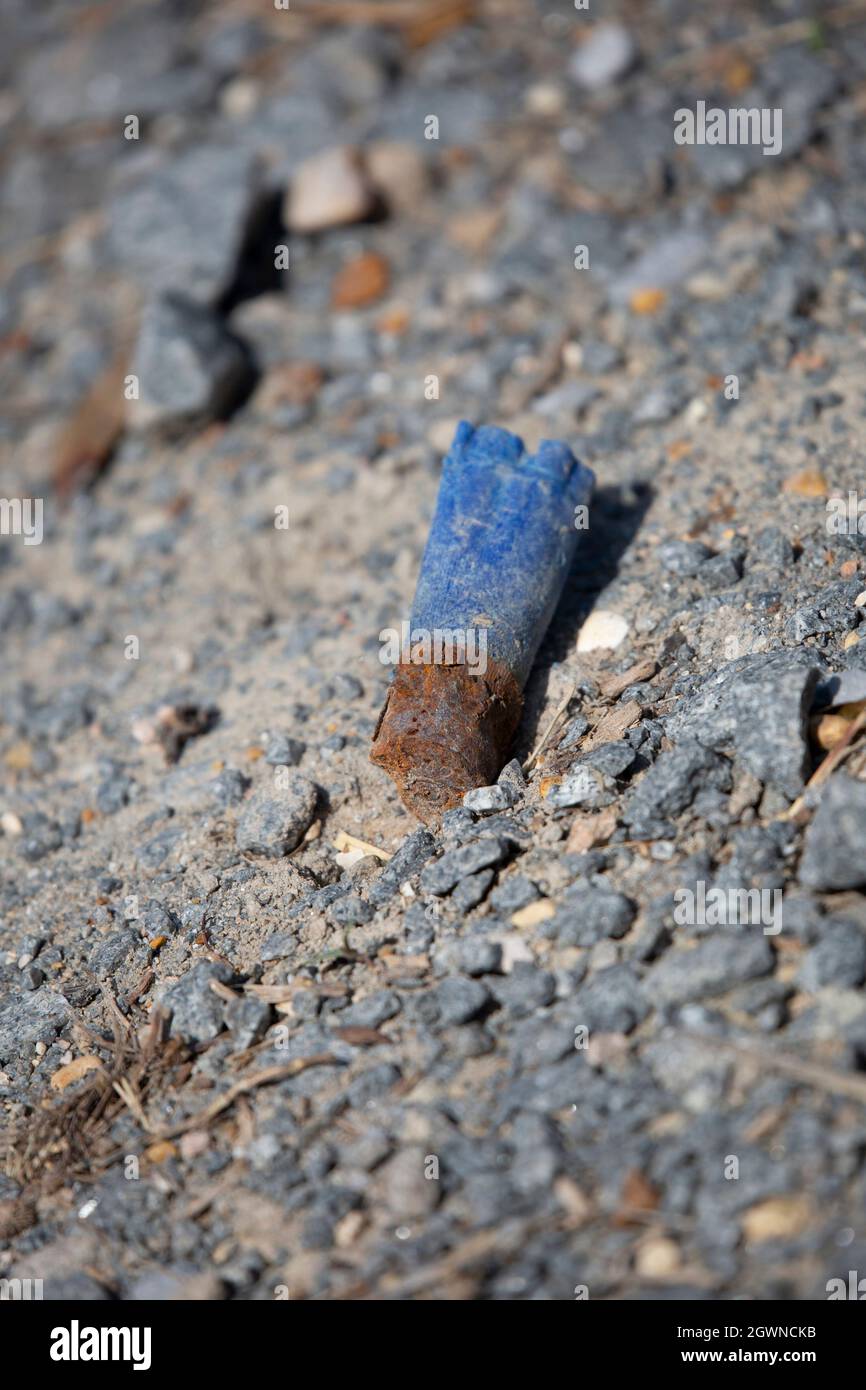 Rusty, discharged blue ammunition shell on the gravel ground Stock ...