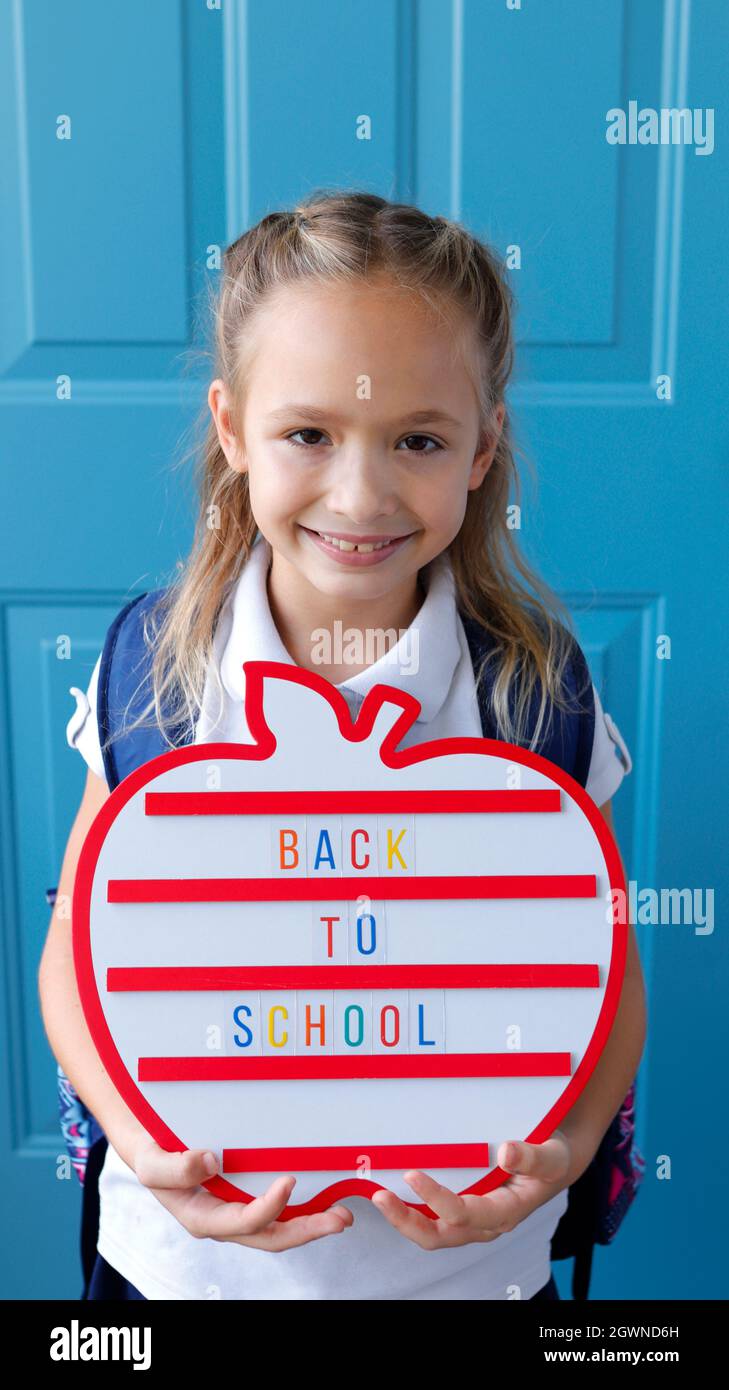 Smiling Girl Holding An Apple Shaped Sign That Say Back To School Stock ...