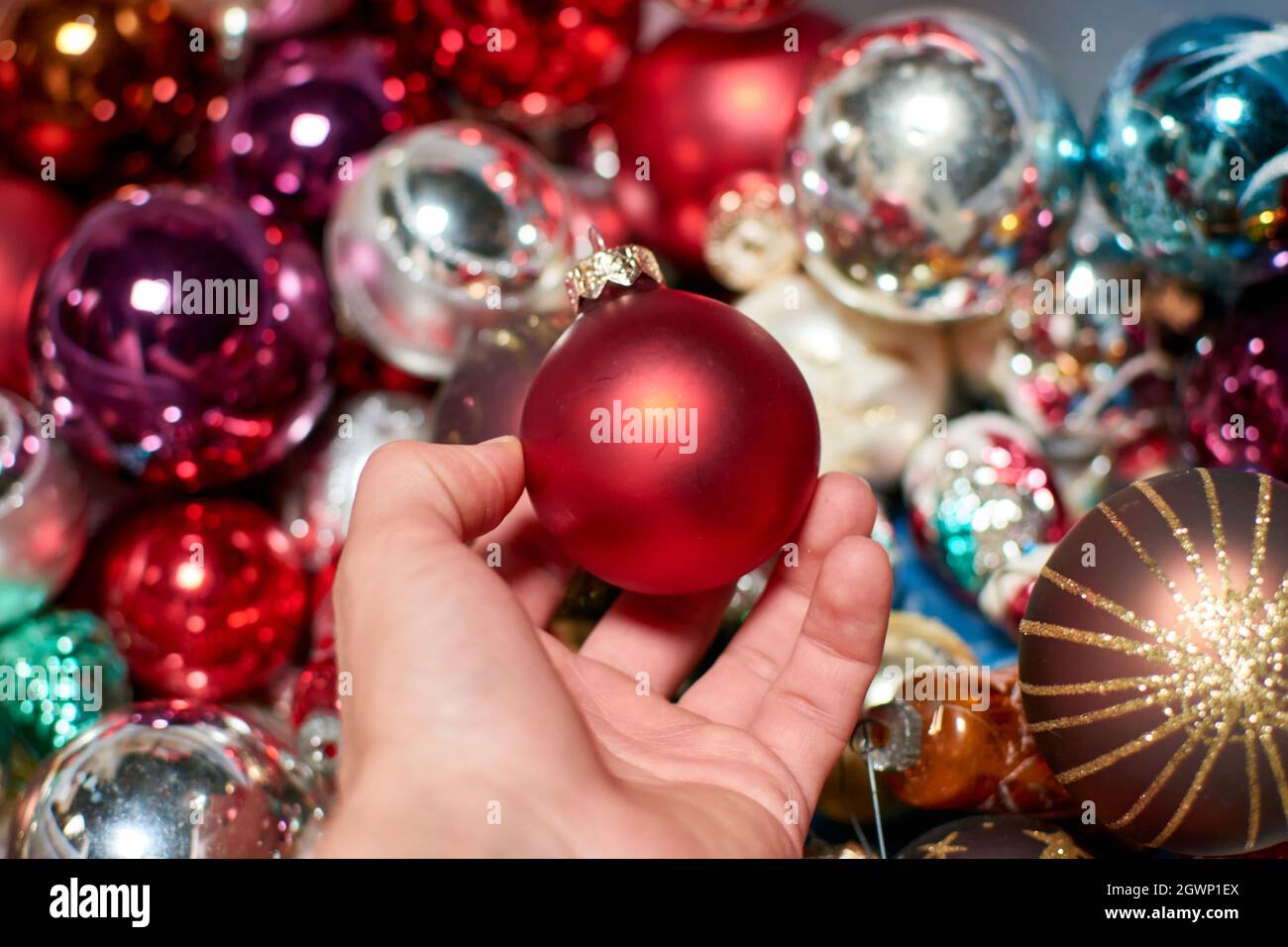 A male hand holding a red ball toy for a Christmas tree Stock Photo - Alamy