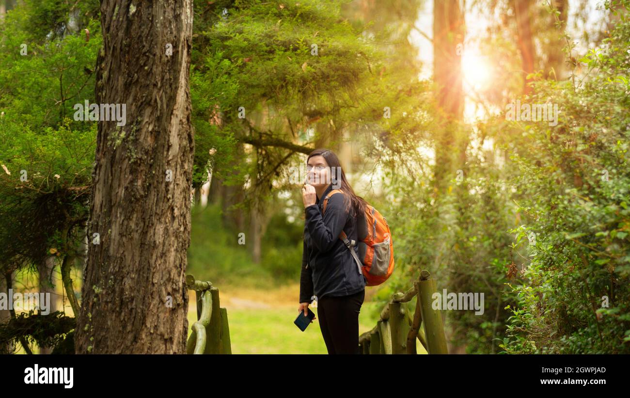 Beautiful Hispanic woman dressed in black with backpack walking alone ...