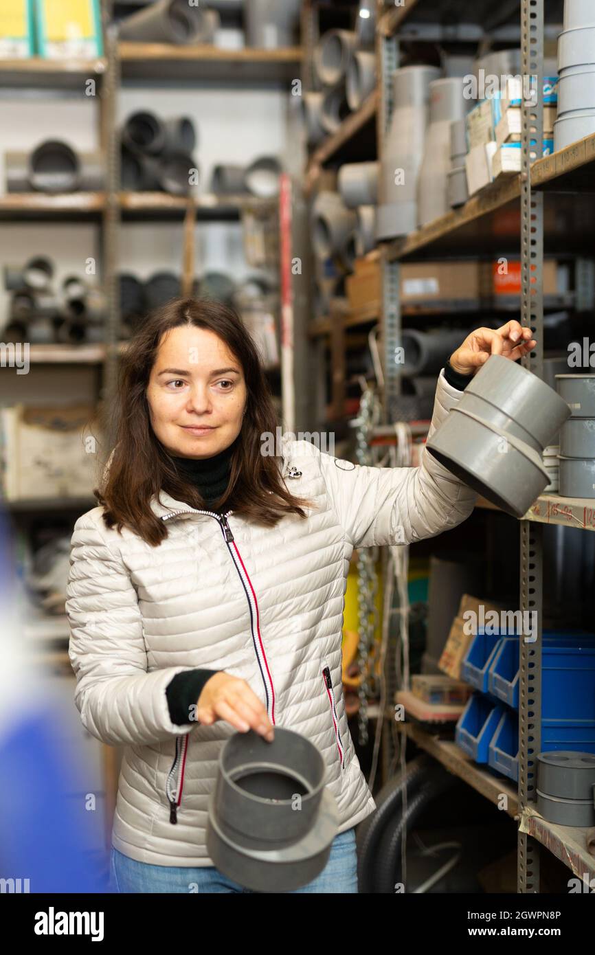 Woman choosing plumbing fittings at hardware store Stock Photo - Alamy