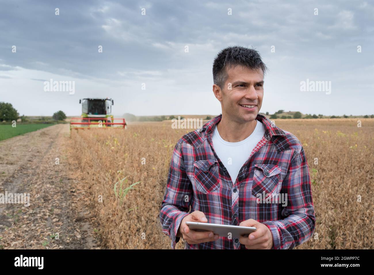 Male agronomist smiling and using tablet modern technology in ...