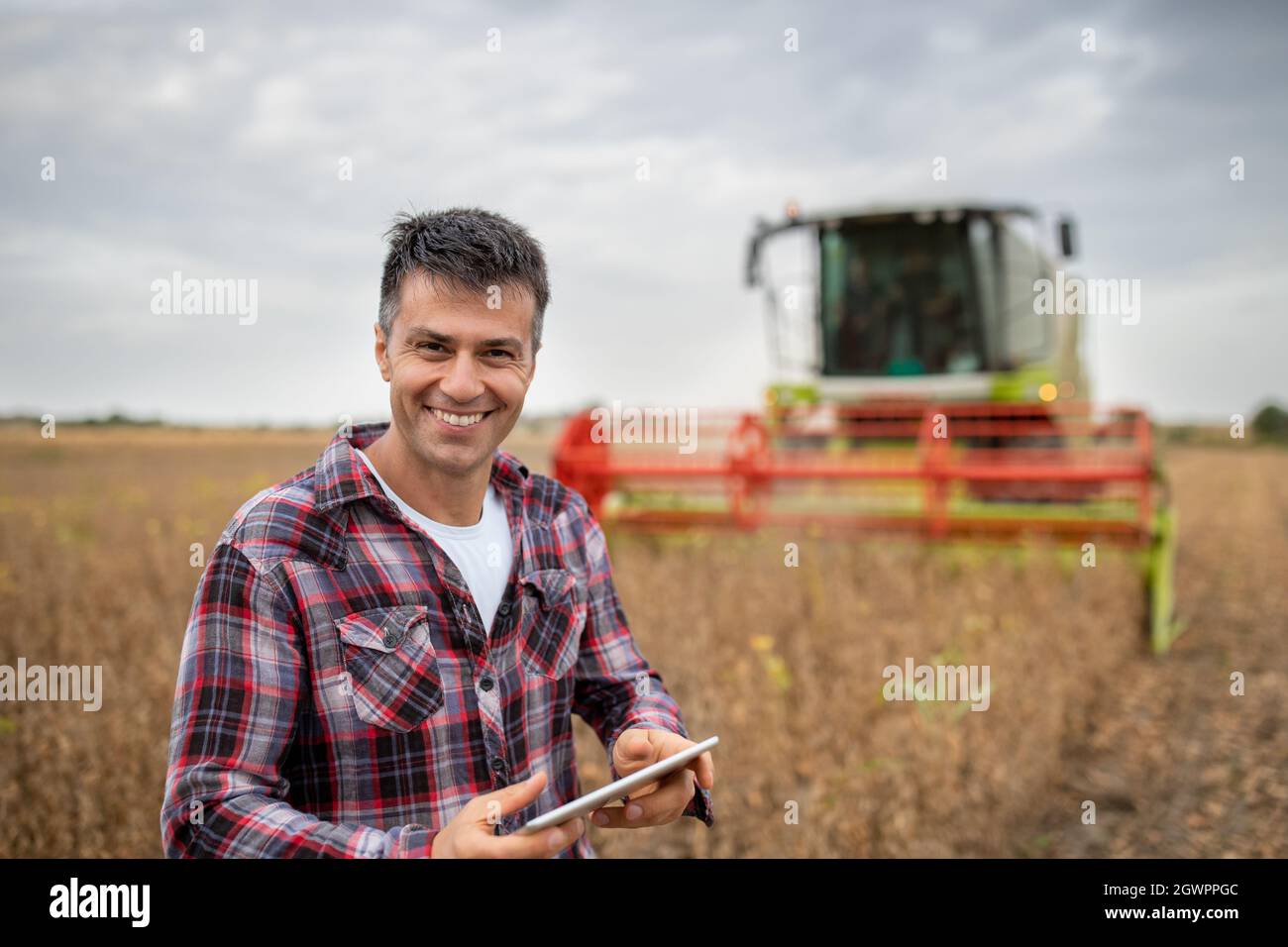 Male agronomist smiling and using tablet modern technology in ...