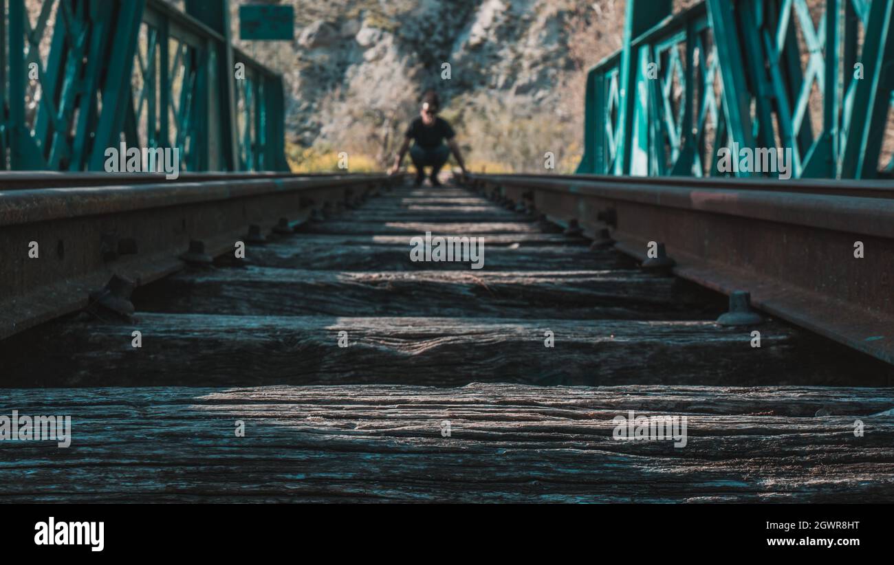 Full Length Of Man Crouching On Railroad Track Stock Photo - Alamy
