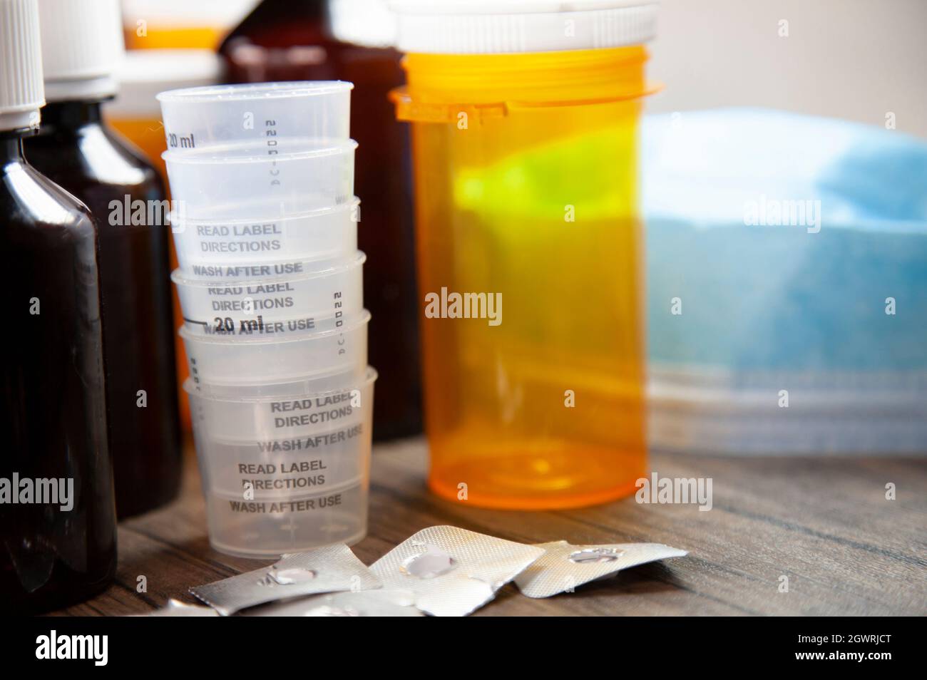 Cough medicine, medication cups, open and empty medication blister ...