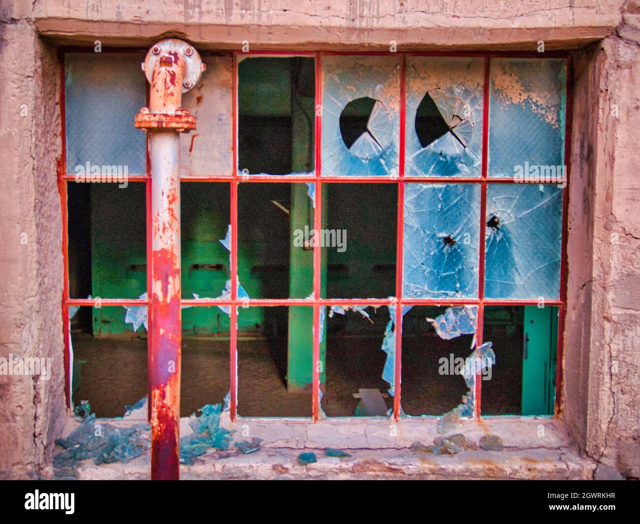 A closeup of an old window with broken glass of an abandoned building ...