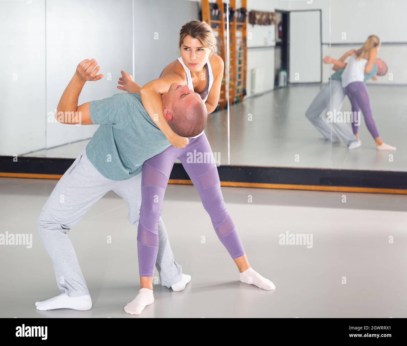 Girl practicing effective self defence techniques in training room ...