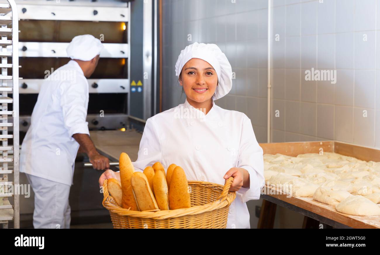 Successful female baker with baked baguettes in bakery Stock Photo - Alamy