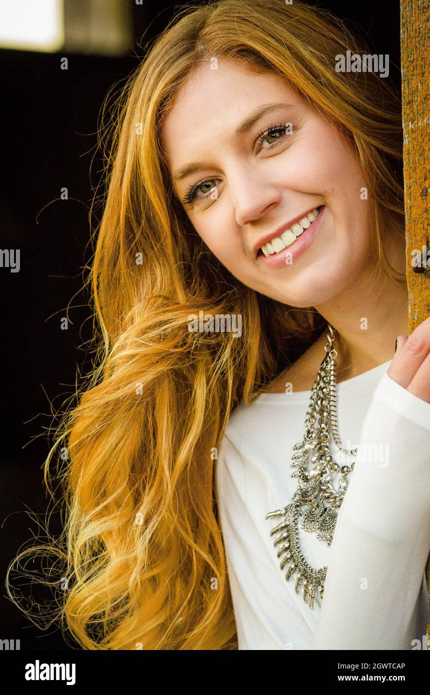 Portrait Of A Smiling Young Woman Peeking Around Corner Stock Photo - Alamy