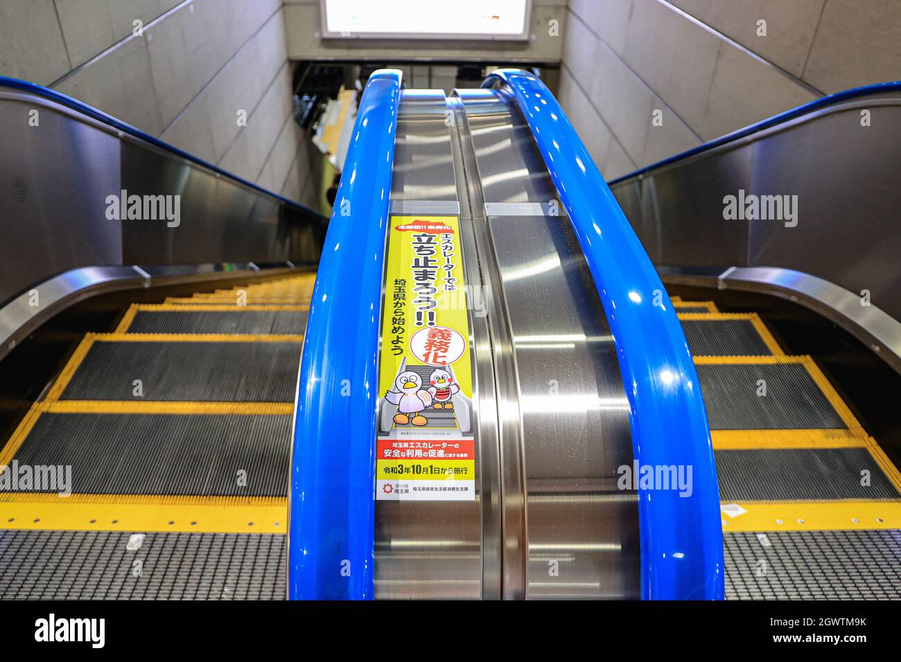 A sign asks passengers to stand still on escalators at the station in ...