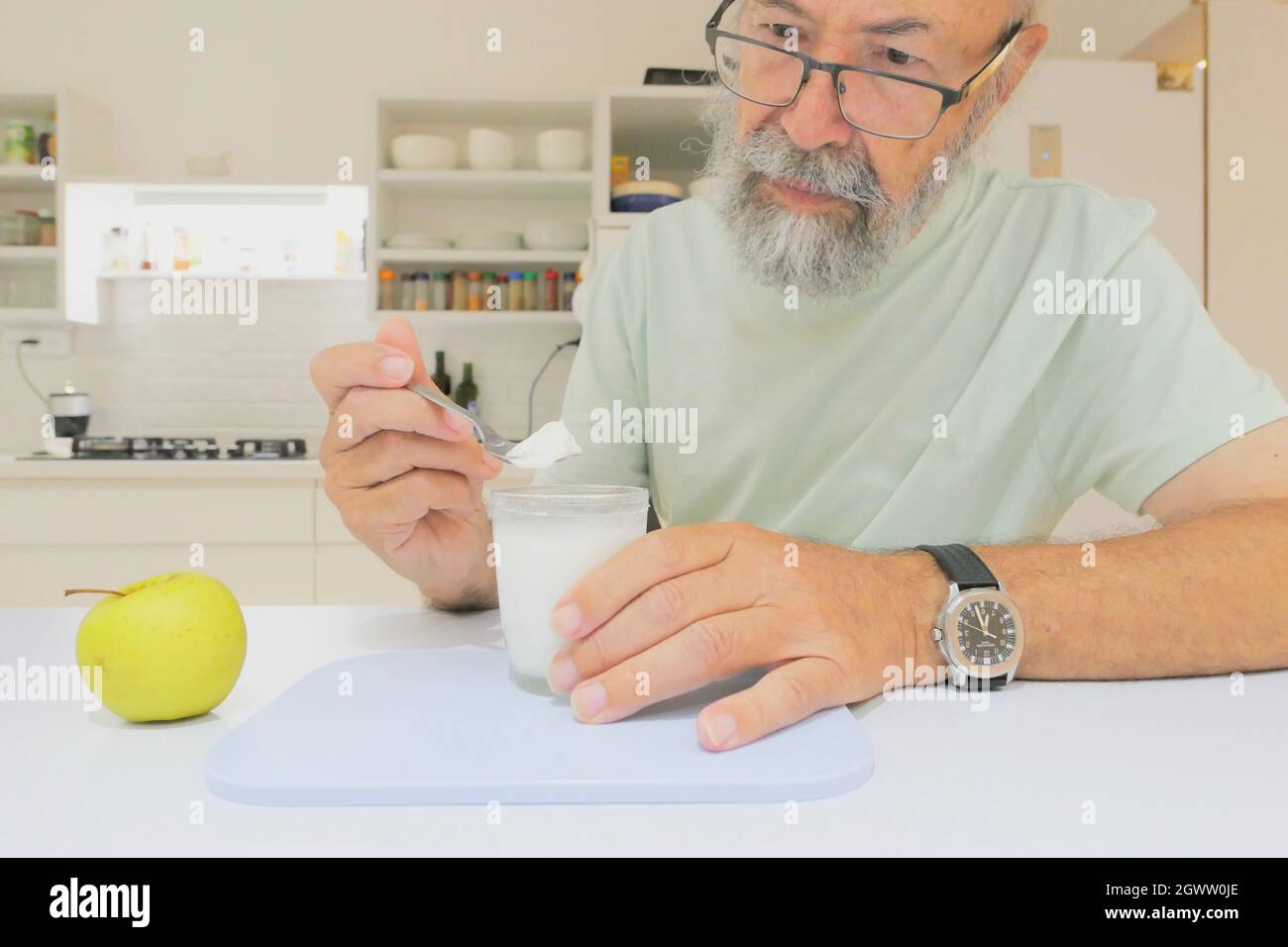 Man eating yogurt in kitchen hi-res stock photography and images - Alamy