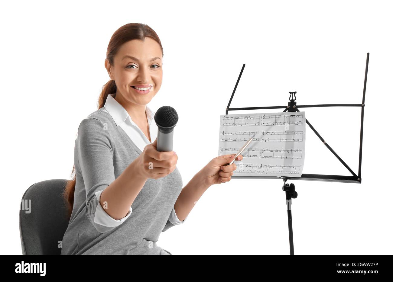 Portrait of female teacher with music sheet and microphone on white ...