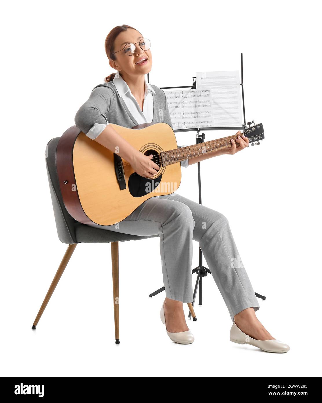 Portrait of singing female teacher with guitar on white background ...
