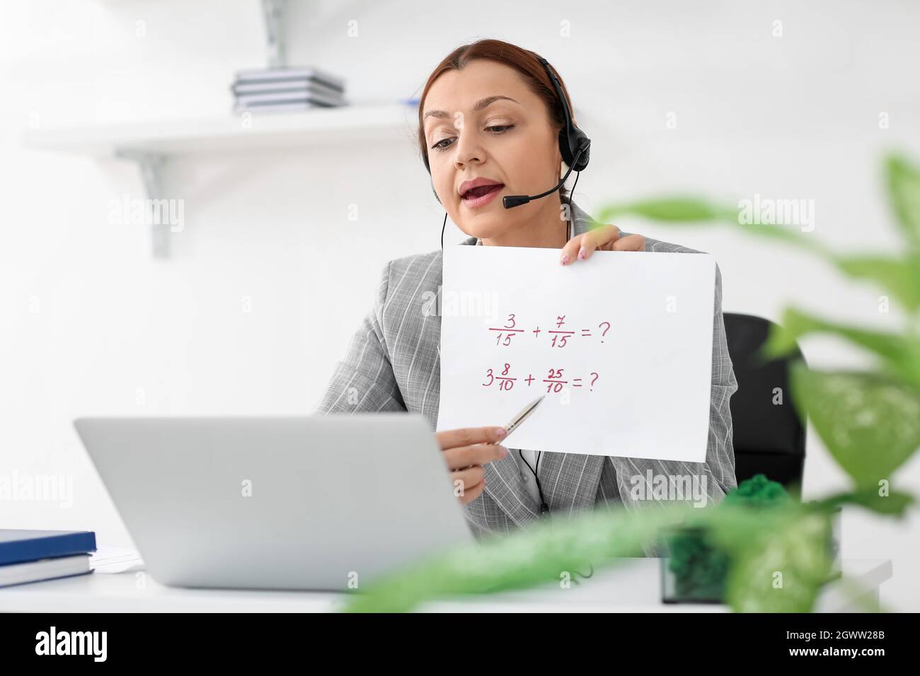 Teacher conducting mathematics lesson online in classroom Stock Photo ...