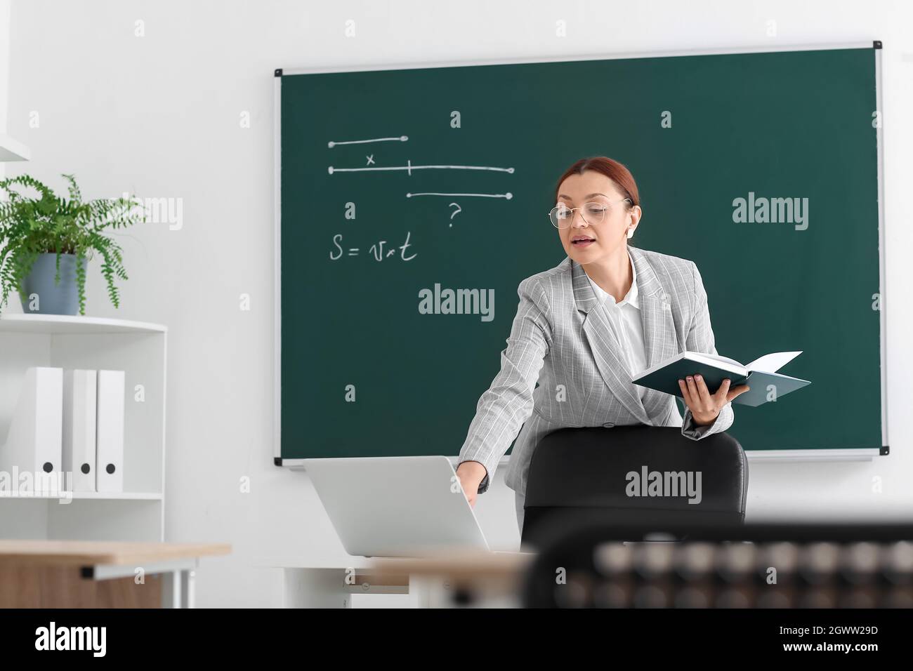 Teacher conducting lesson online in classroom Stock Photo - Alamy