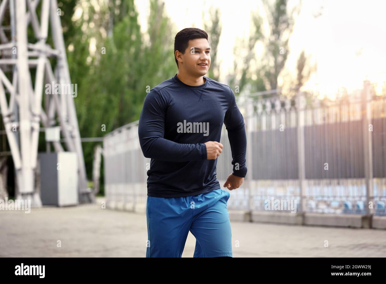 Muscular young man running at stadium Stock Photo - Alamy