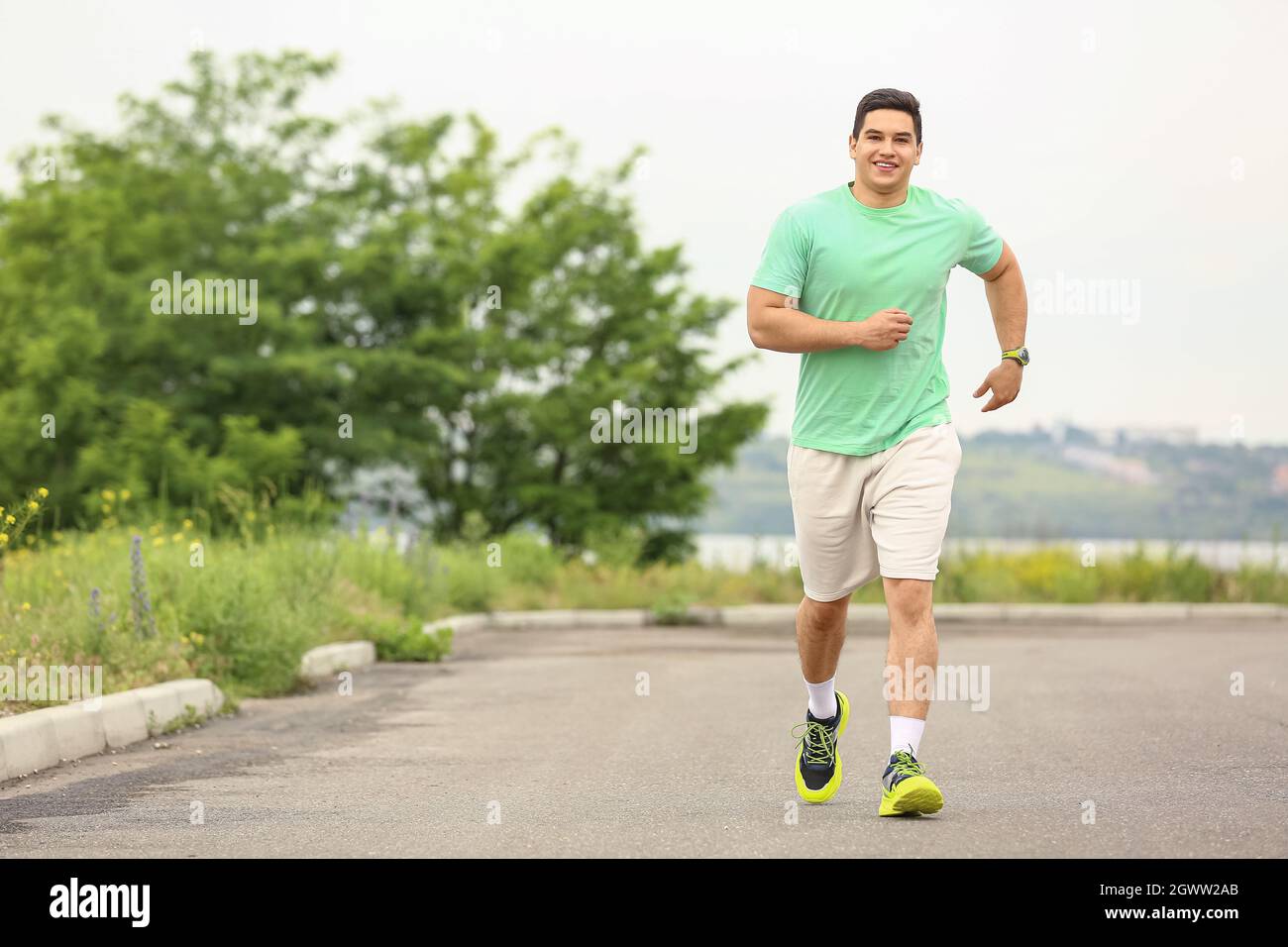 Muscular young man running outdoors Stock Photo - Alamy