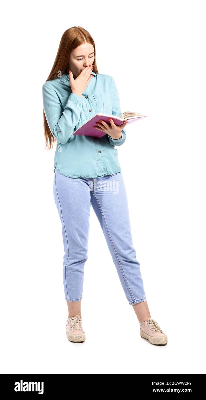 Bored young woman reading book on white background Stock Photo - Alamy