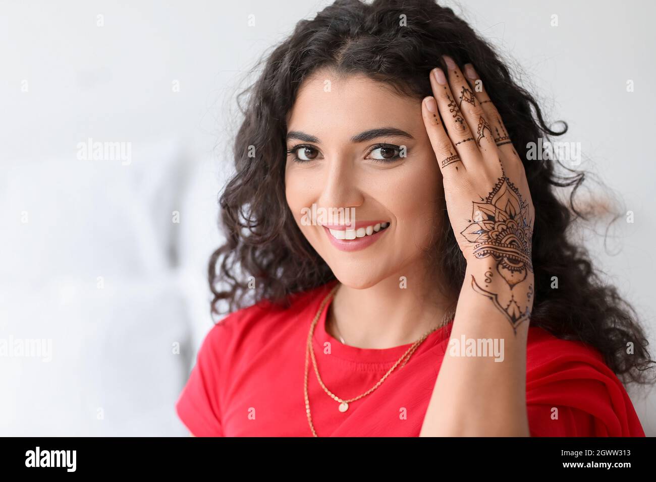 Beautiful Indian woman with henna tattoo at home Stock Photo - Alamy