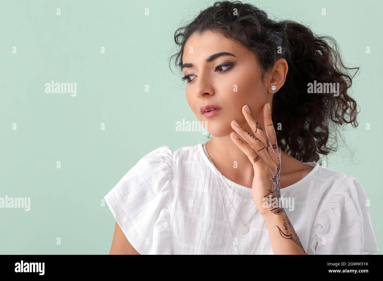 Beautiful Indian woman with henna tattoo on color background Stock ...