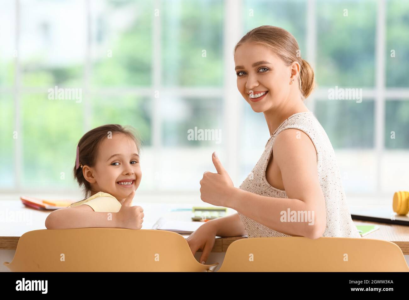 Little girl and her mother showing thumbs-up at home Stock Photo - Alamy