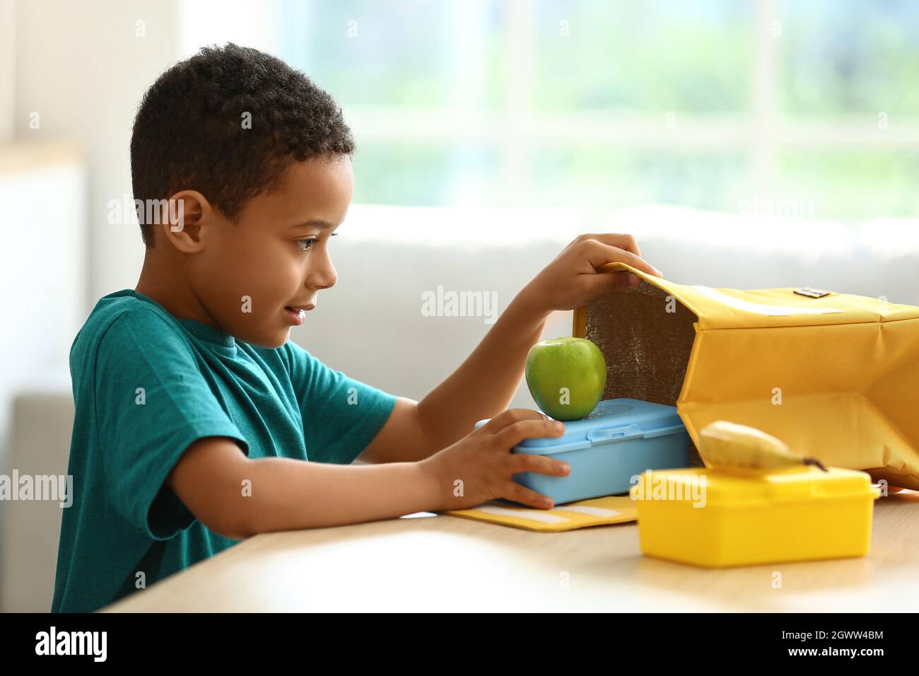 Cute little boy putting his lunch in bag Stock Photo - Alamy