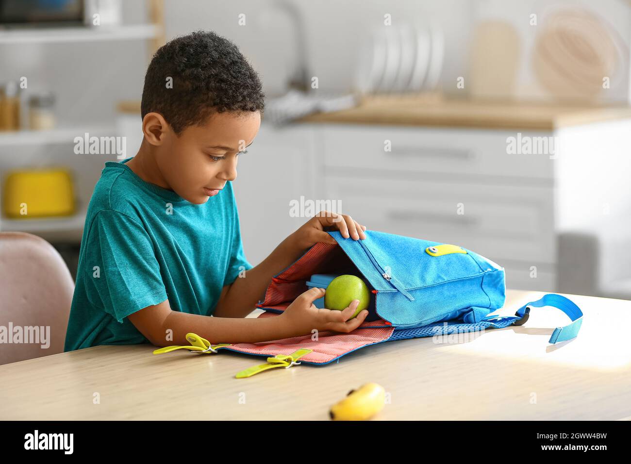 Cute little boy putting his school lunch in bag Stock Photo - Alamy