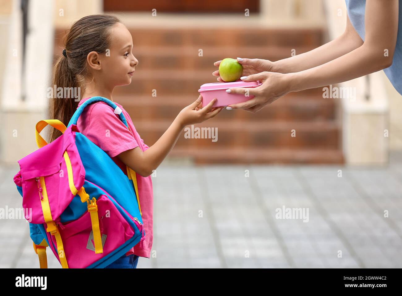 Mother giving lunch to her little daughter before school Stock Photo ...