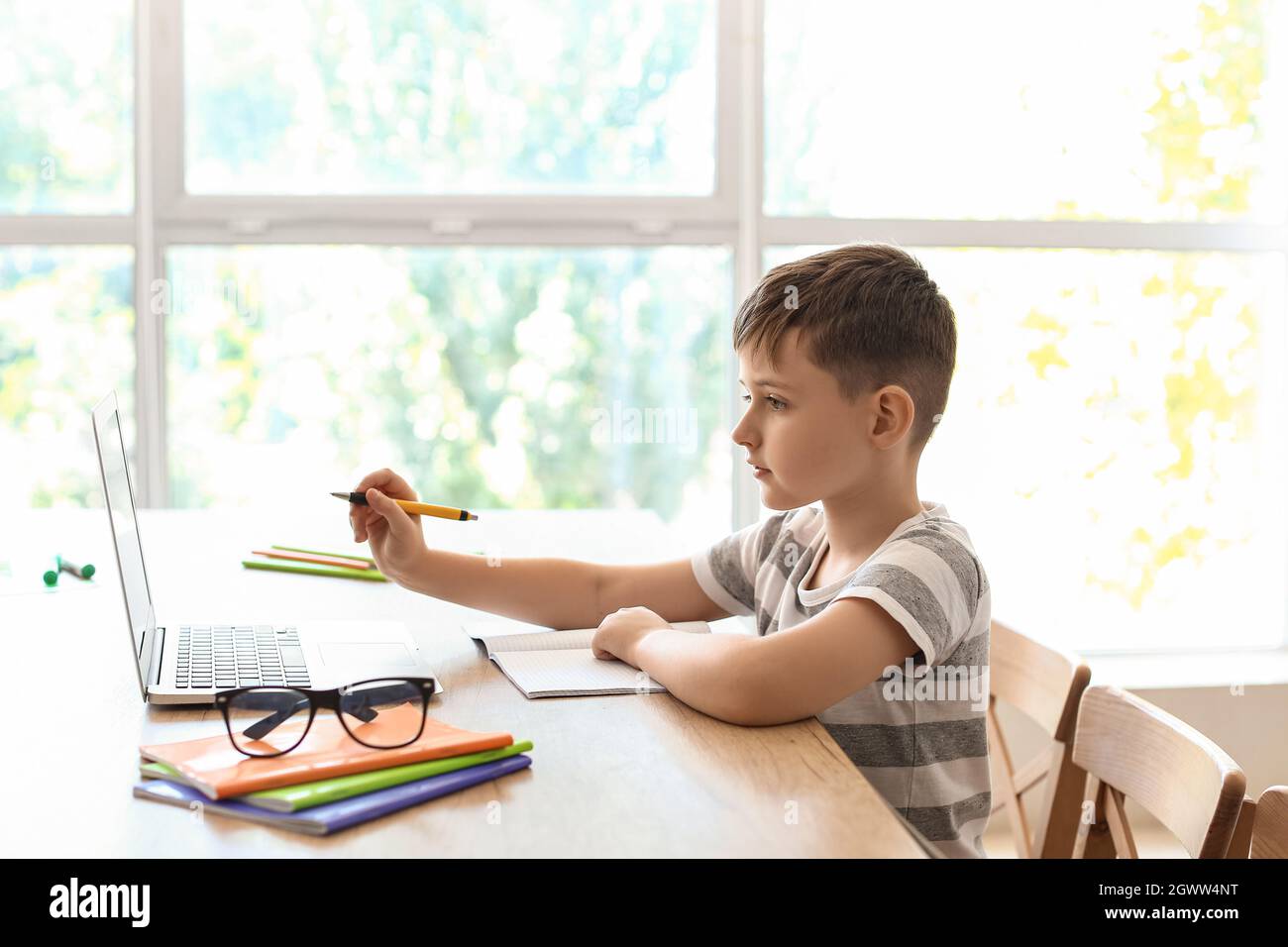 Little boy doing lessons online at home Stock Photo - Alamy