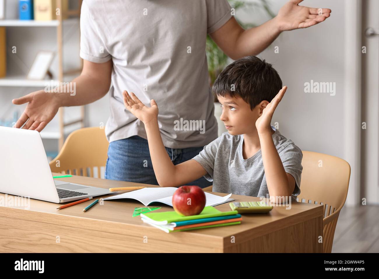 Confused little boy and his father doing lessons at home Stock Photo ...
