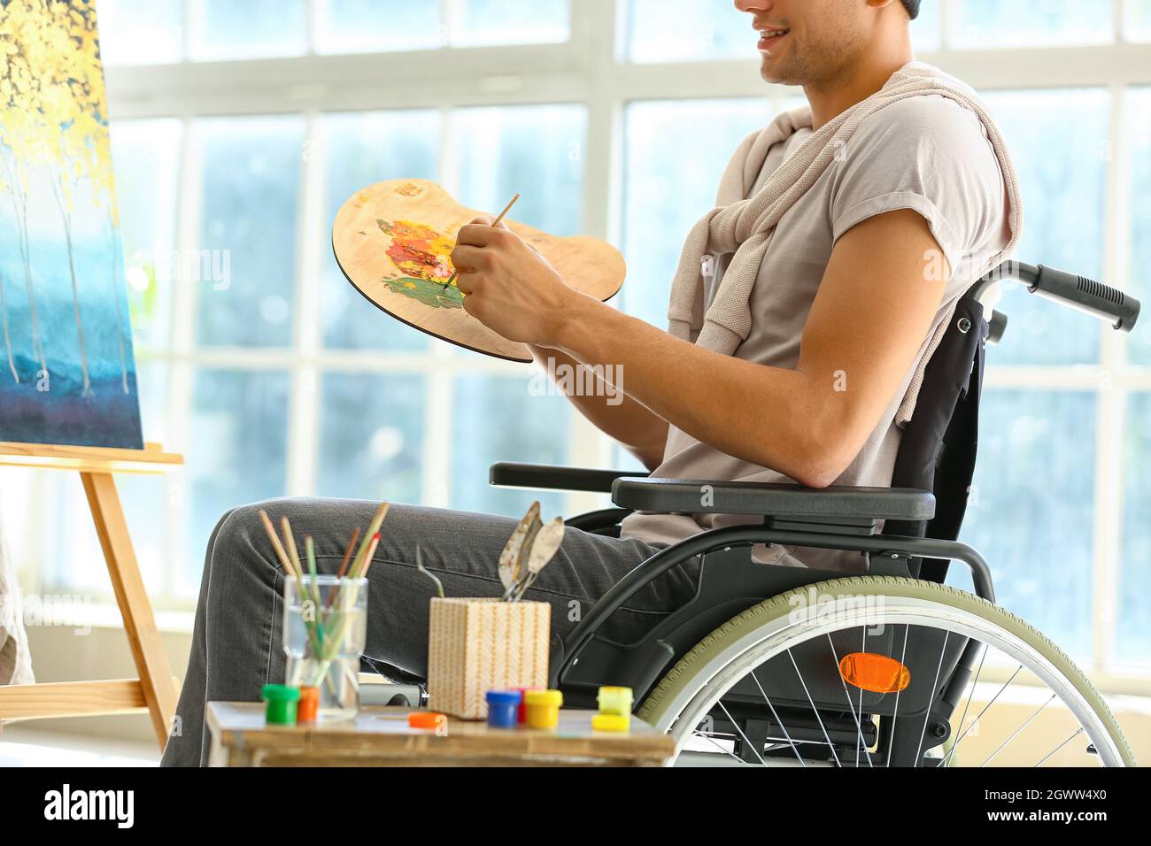 Young handicapped artist painting in workshop Stock Photo - Alamy