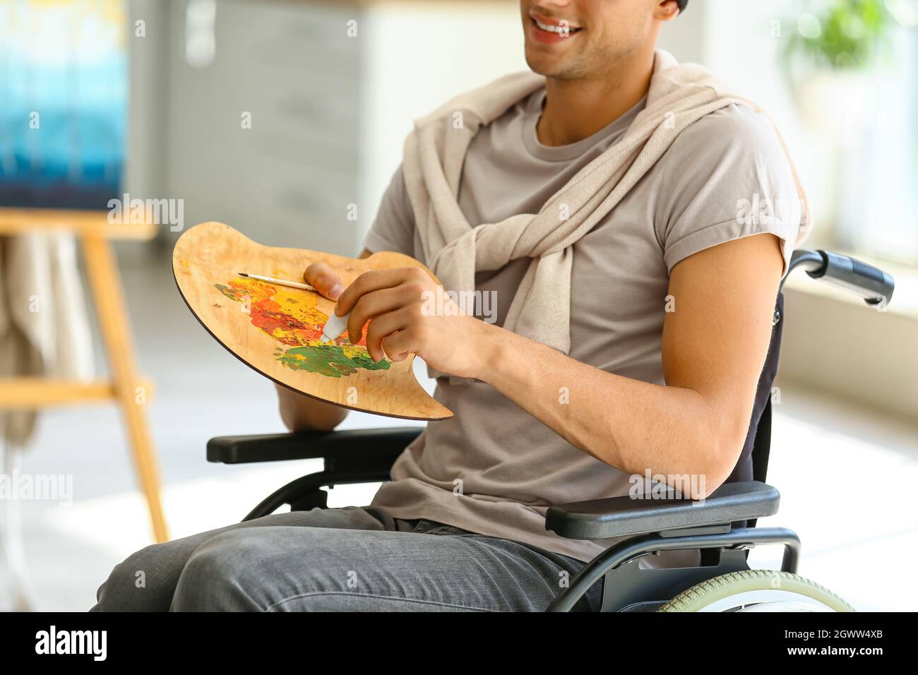 Young handicapped artist painting in workshop Stock Photo - Alamy