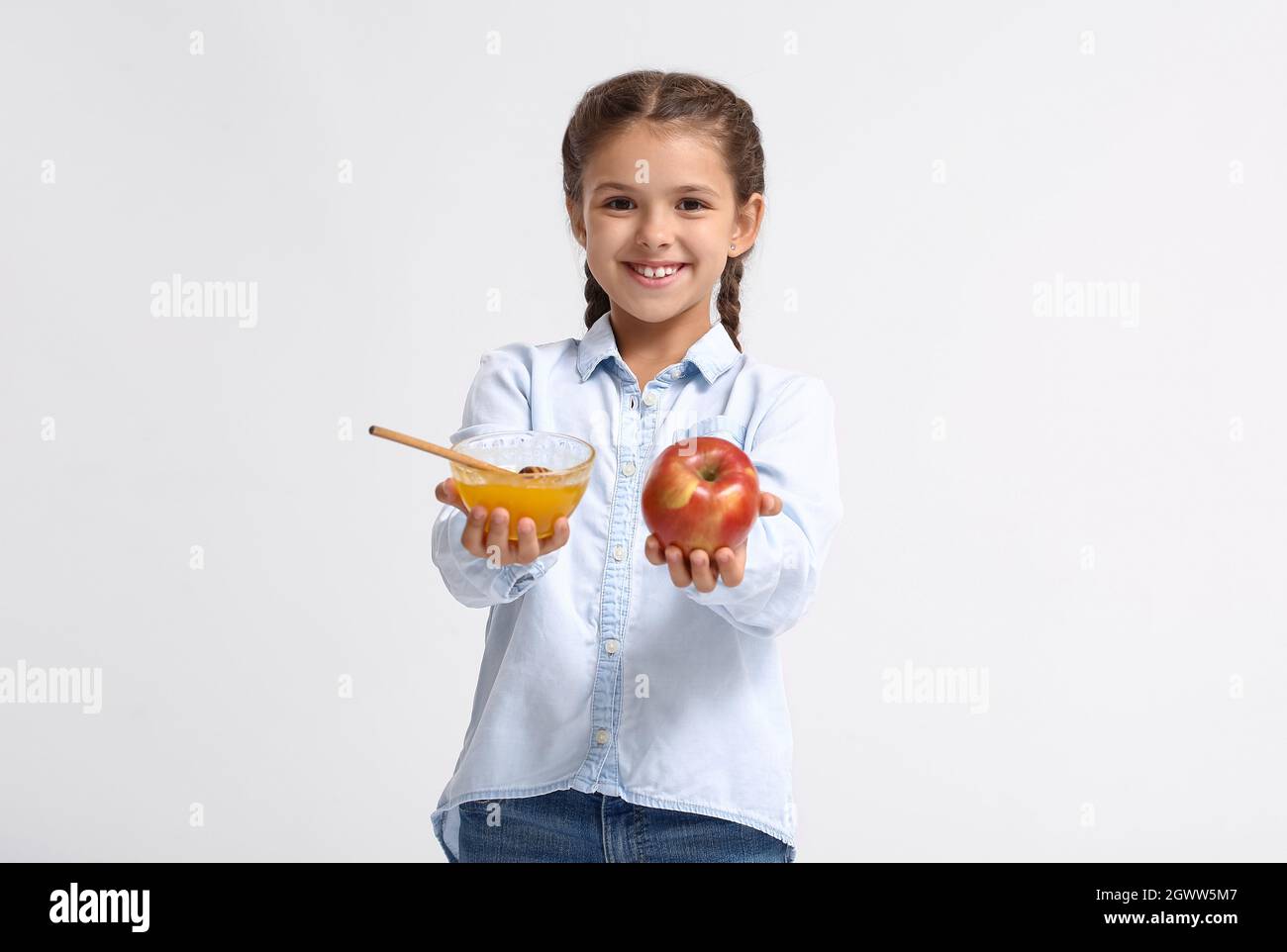 Little girl with honey and apple on white background. Rosh Hashanah ...